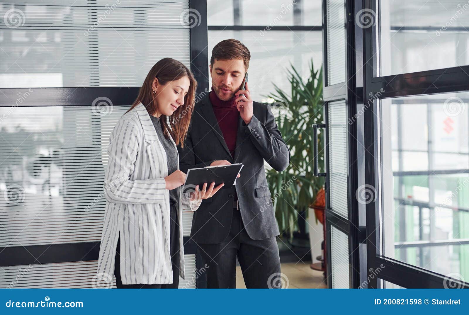 Two Office Workers in Formal Clothes Indoors Have a Busy Working Day ...