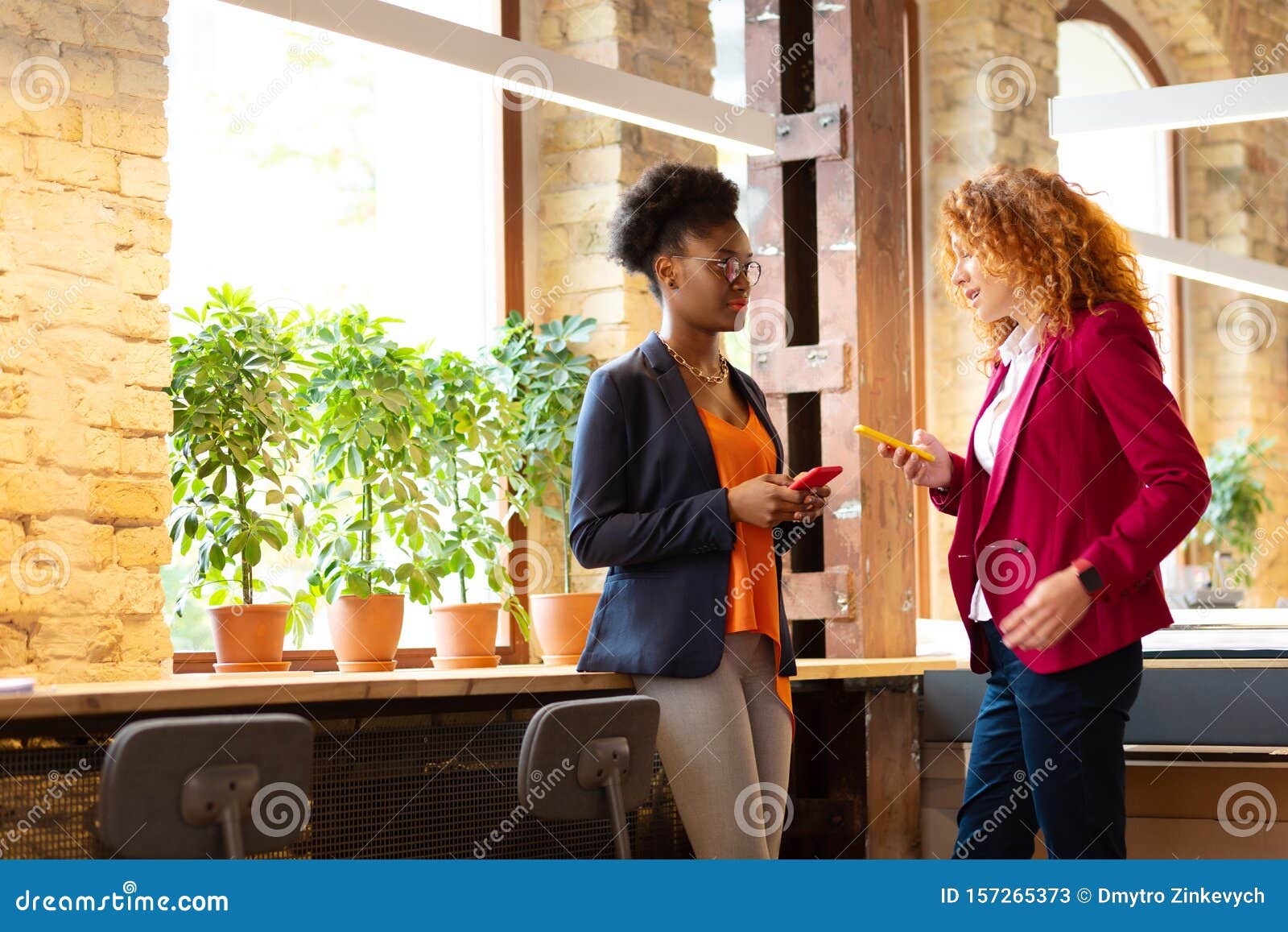 Two Office Workers Using Smartphones while Having Break Stock Image ...