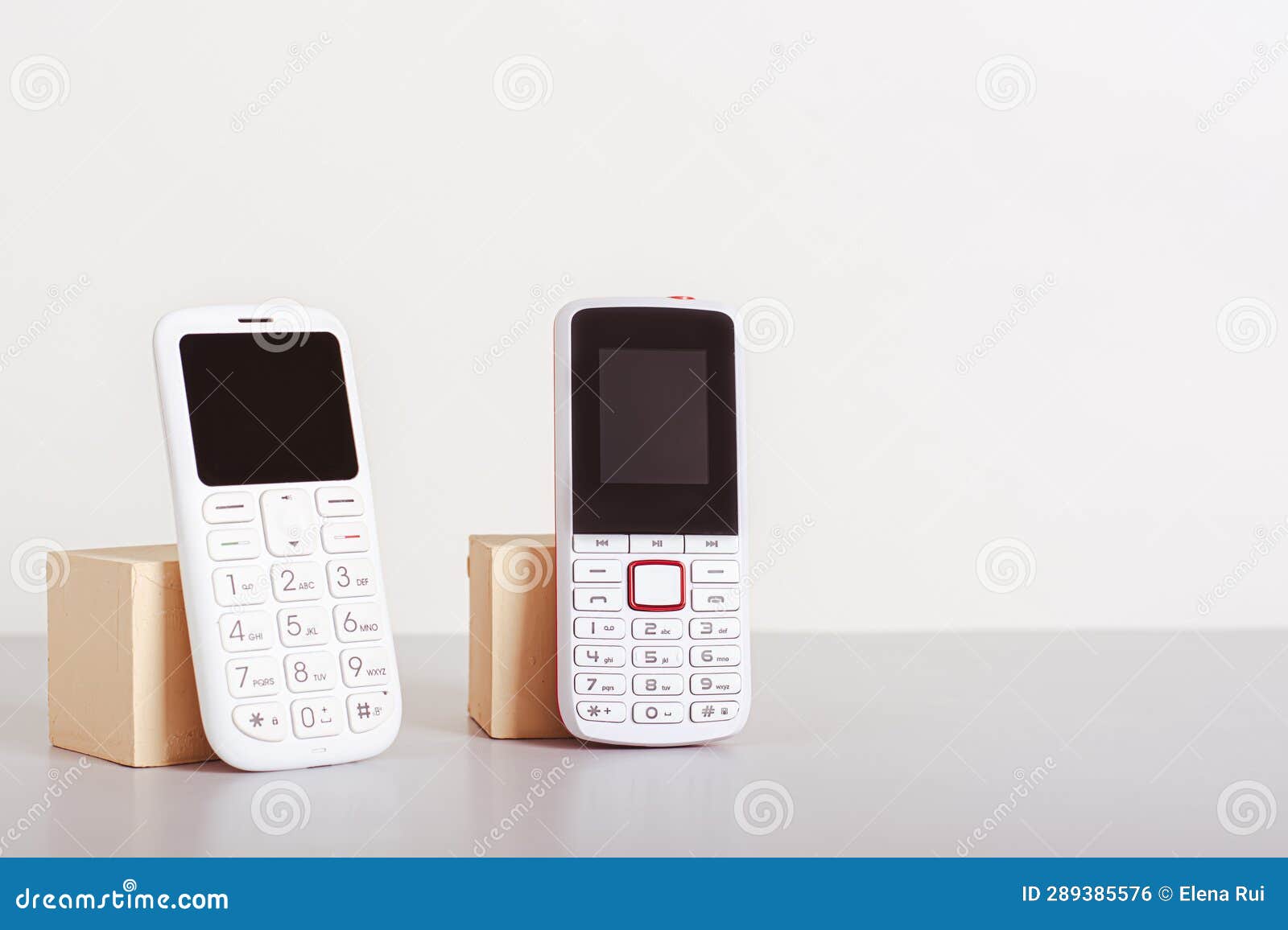Two Old-fashioned White Push-button Telephones are on the Table Stock ...