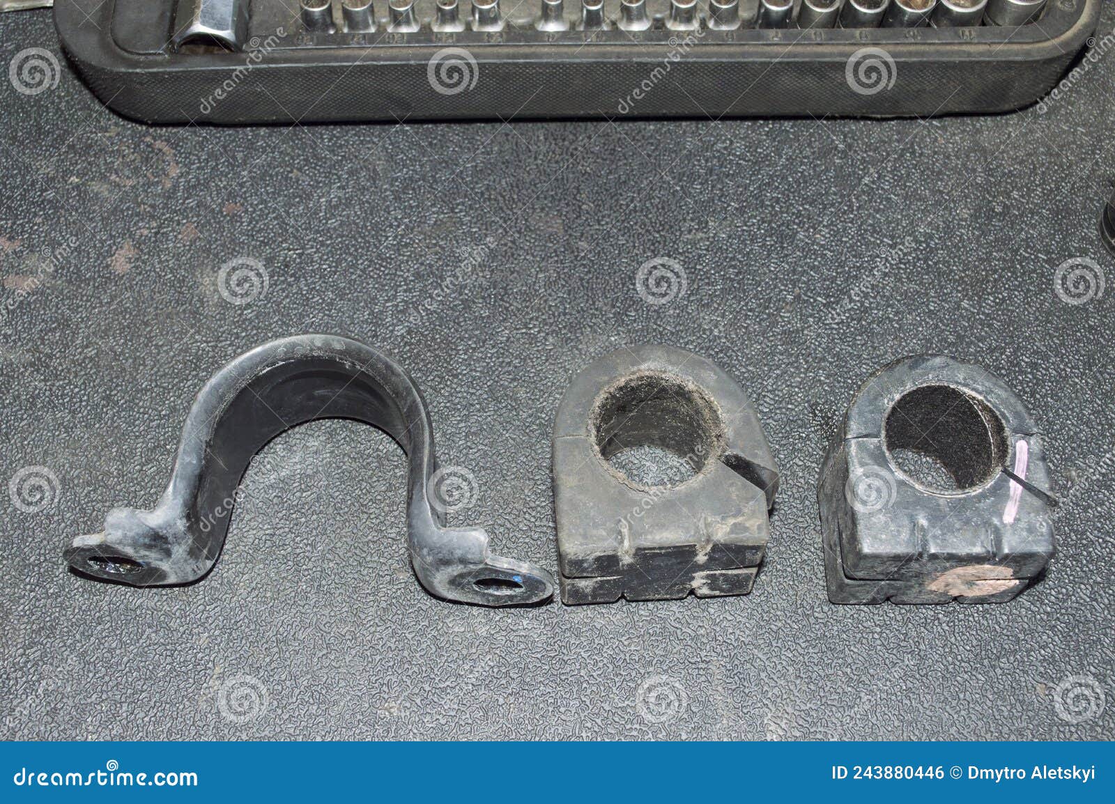 Two Old Rubber Stabilizer Bushings and a Bracket are Lying on a Gray ...