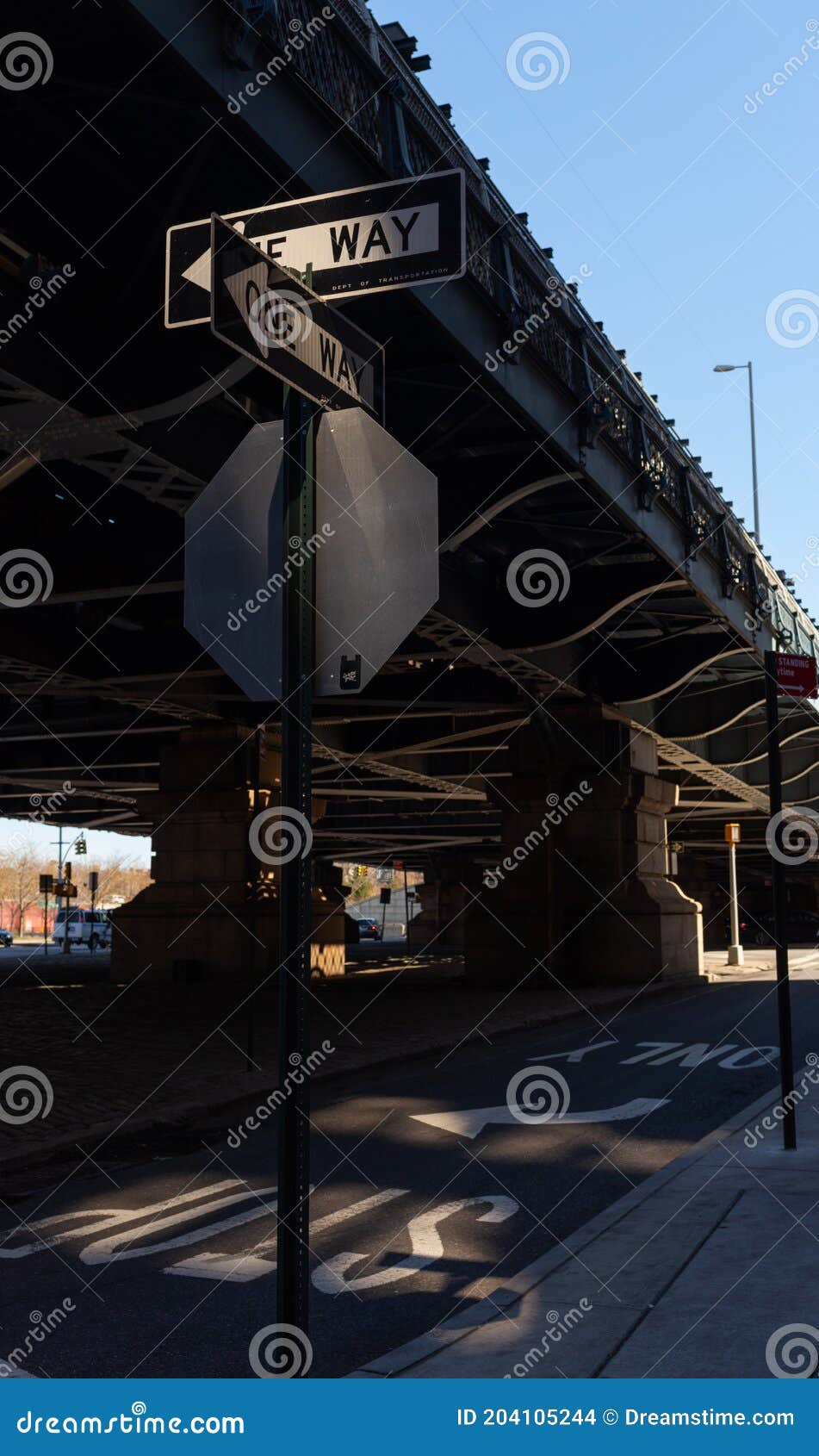 Two `One Way` Signs Intersecting Under a Bridge in Dramatic Light Stock ...