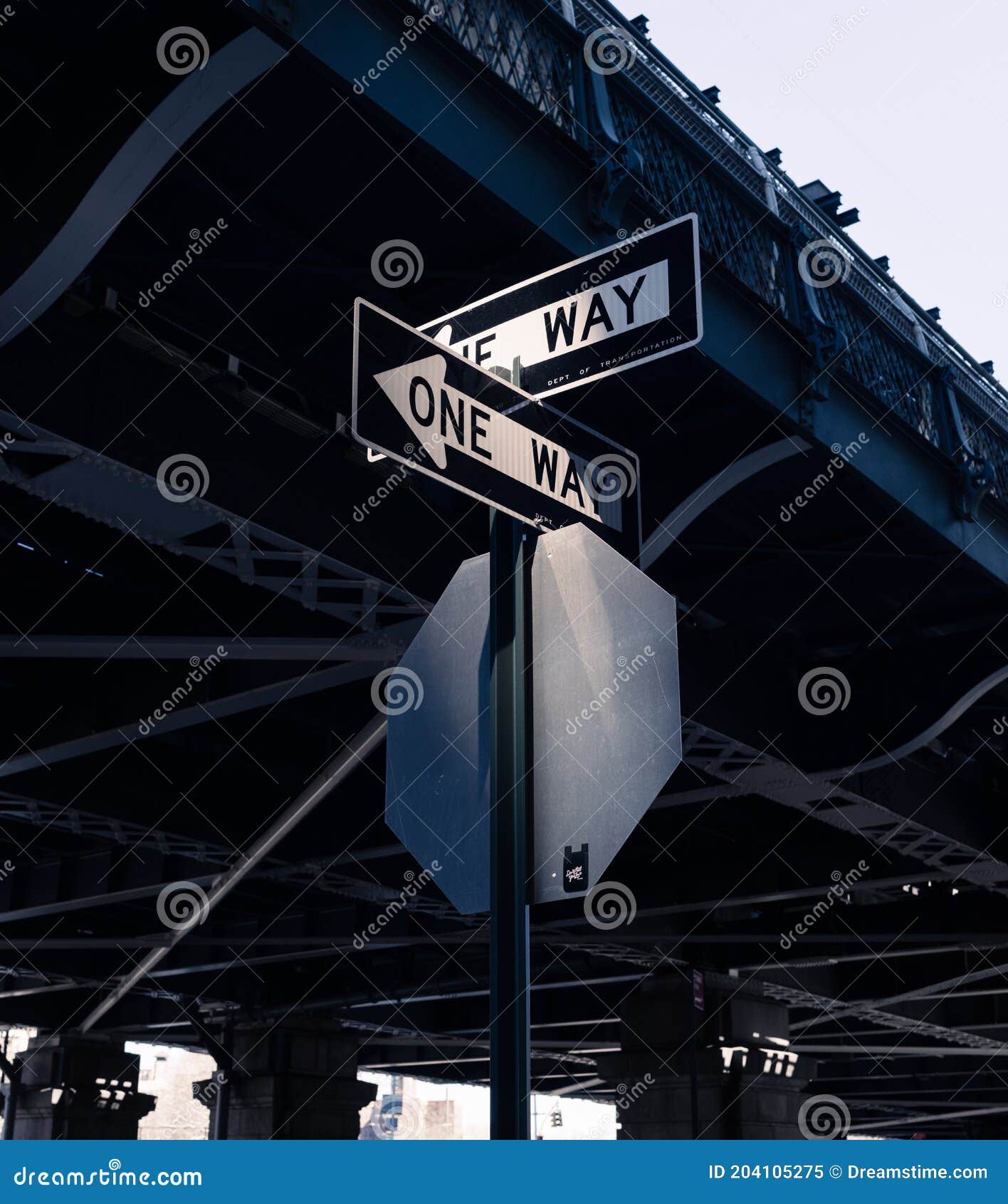 Two `One Way` Signs Intersecting Under a Bridge in Dramatic Light Stock ...