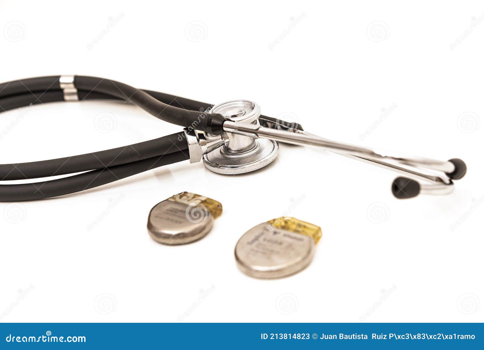 TWO PACEMAKER BATTERIES SURROUNDED by a STETHOSCOPE WHITE BACKGROUND ...
