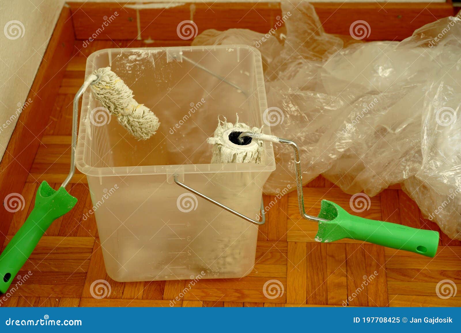 Two Paint Rollers in a Container on the Floor. the Paint is Dripping ...
