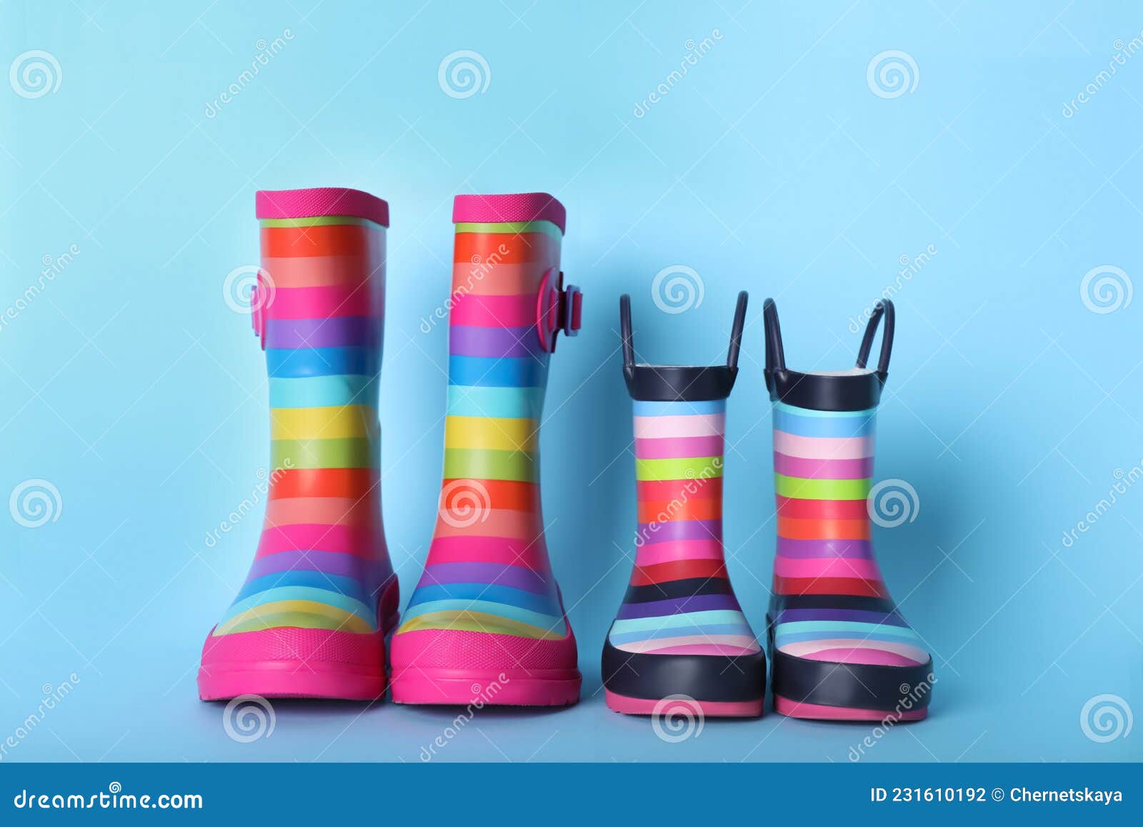 Two Pairs of Striped Rubber Boots on Light Blue Background Stock Photo ...