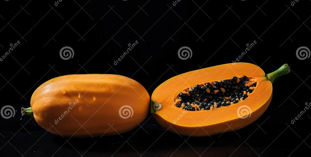 Two Papaya S are Shown on a Black Table Stock Photo - Image of papayas ...
