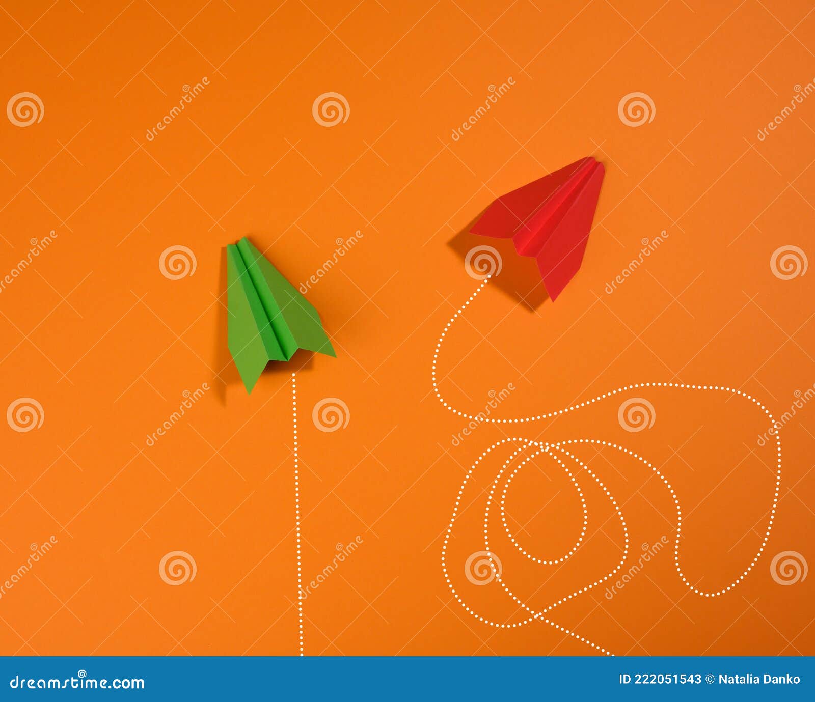 Two Paper Airplanes with Different Trajectory of Movement on an Orange ...