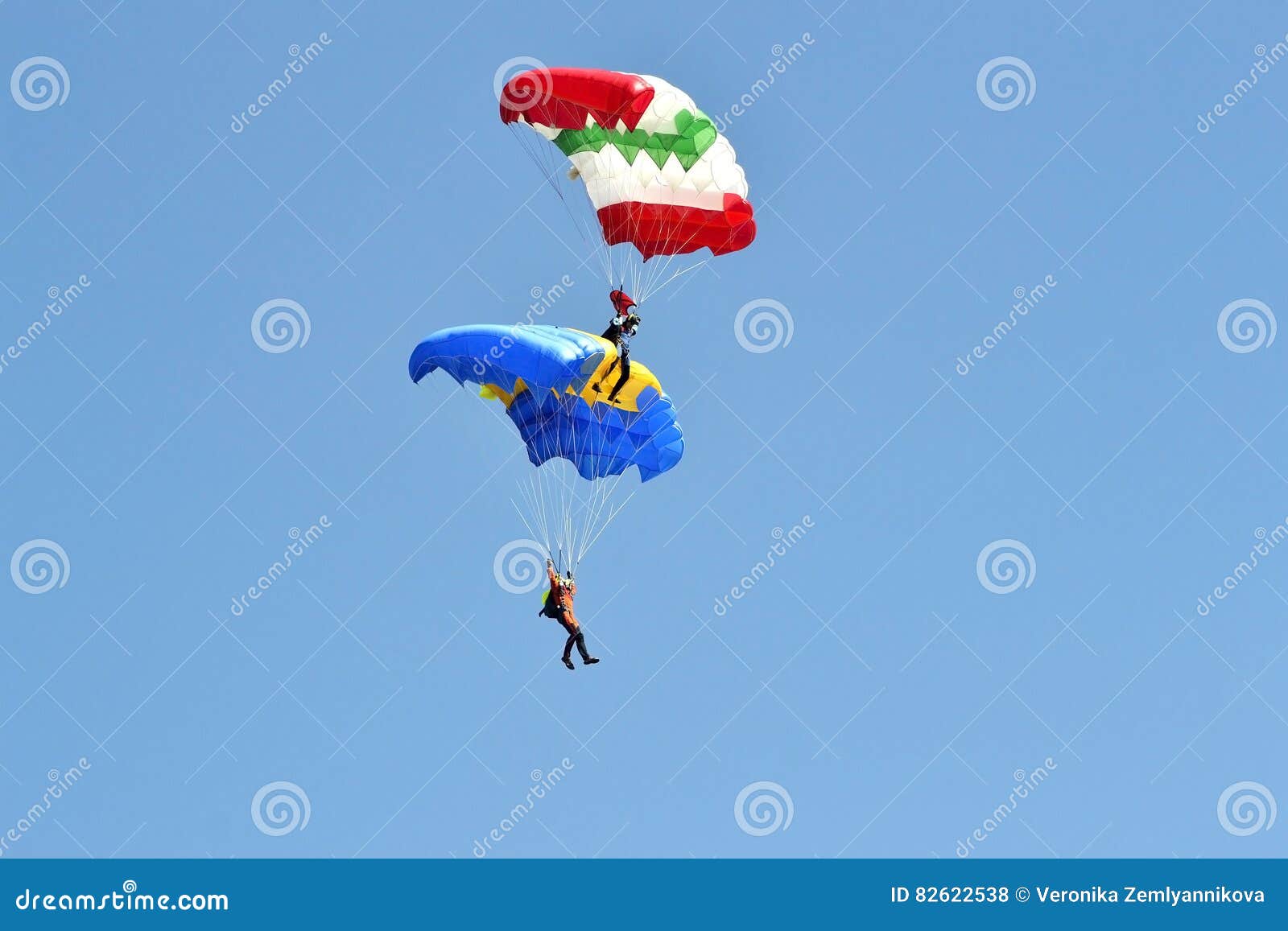 Two Parachutists with Multi-colored Parachutes Fly in the Sky ...