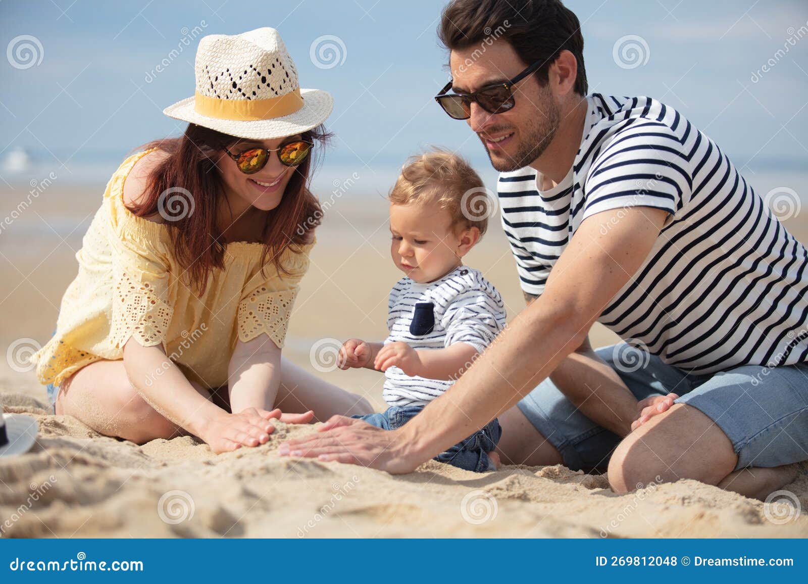 Two Parents and Their Toddler Playing Together in Sand Stock Photo ...