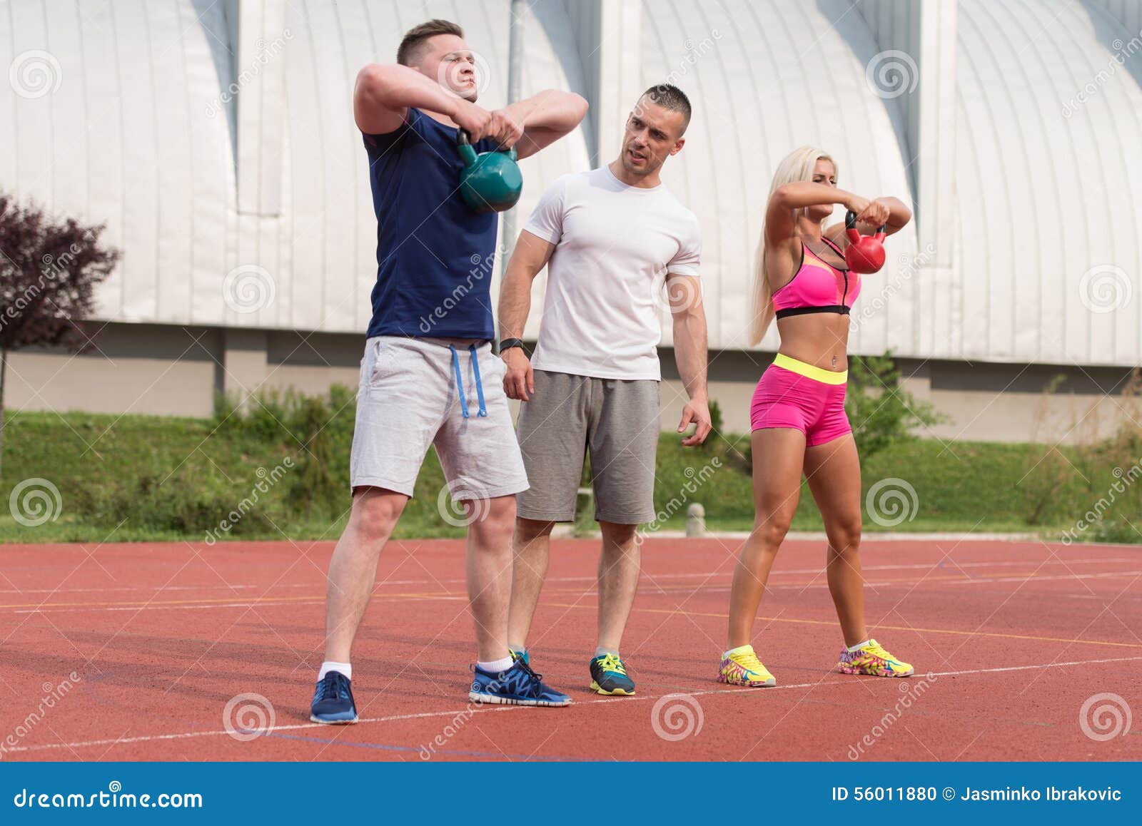 Two People Doing Kettlebell Exercise Outdoor with Instructor Stock ...