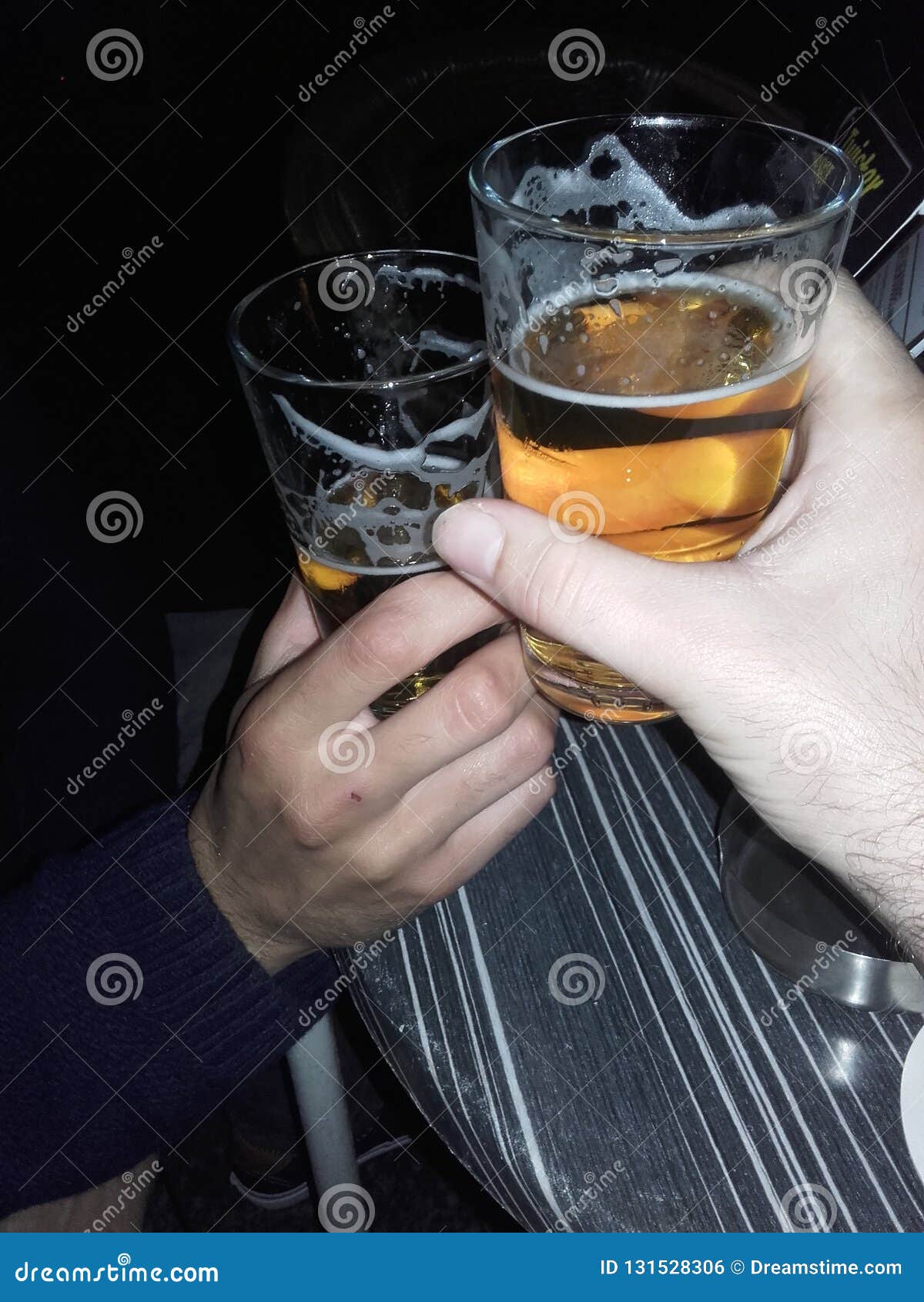 Two people drinking a beer stock photo. Image of hands - 131528306