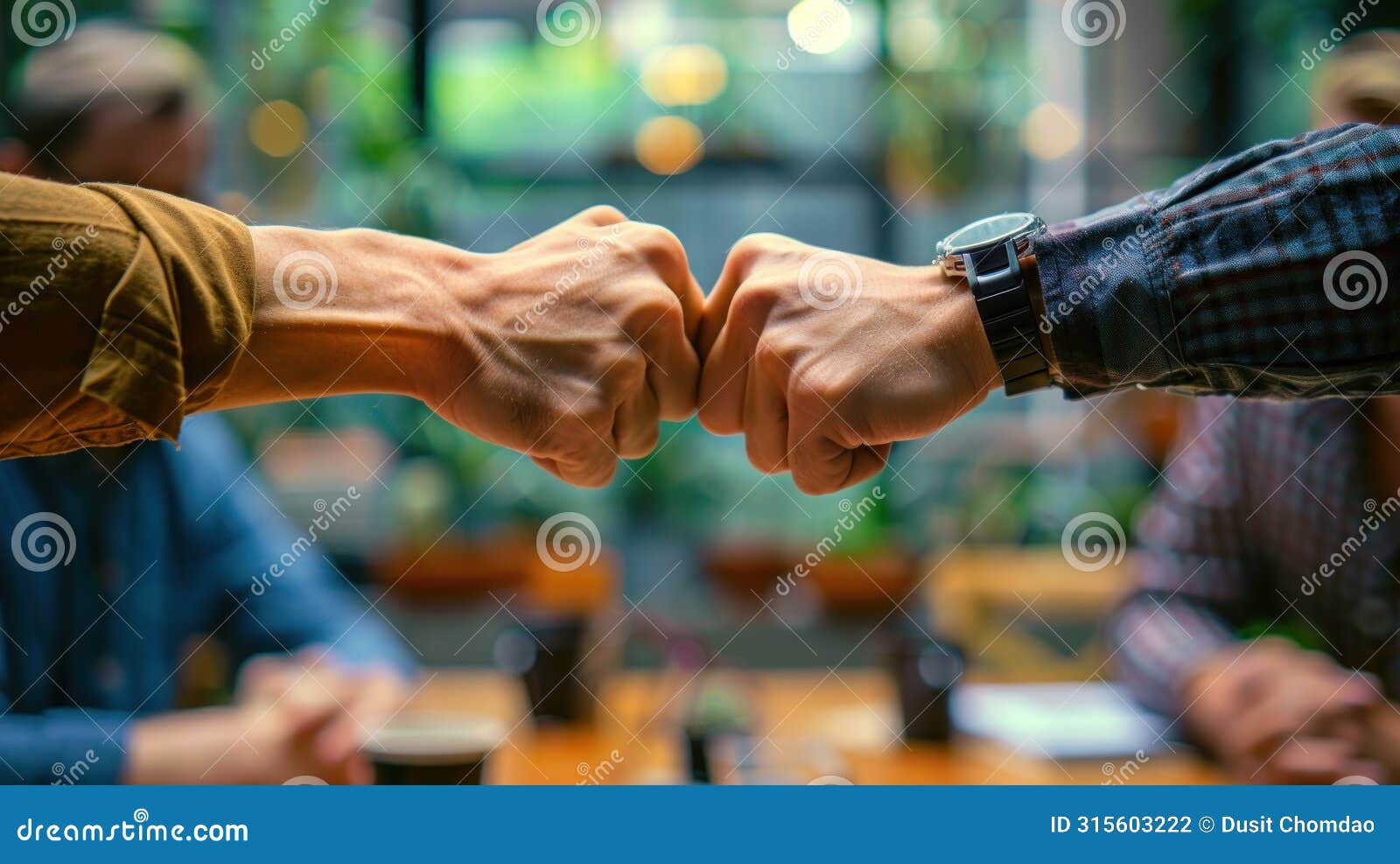 Two People Fist Bumping Each Other in a Group of People Stock Photo ...