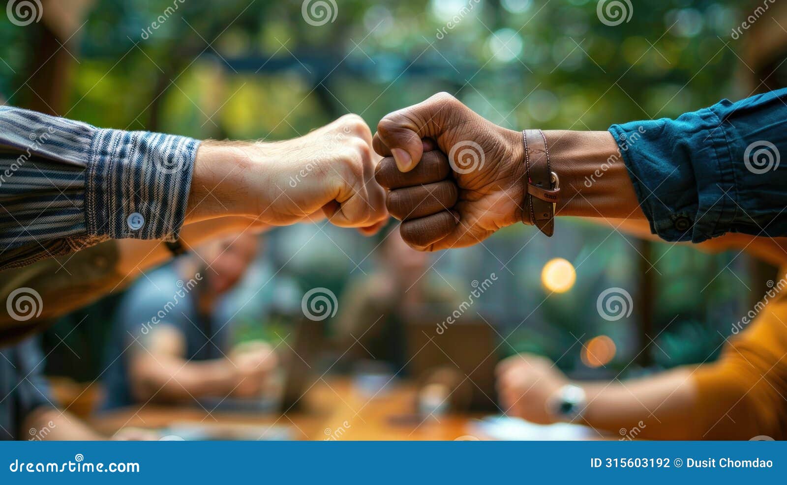 Two People Fist Bumping Each Other in a Group of People Stock Photo ...