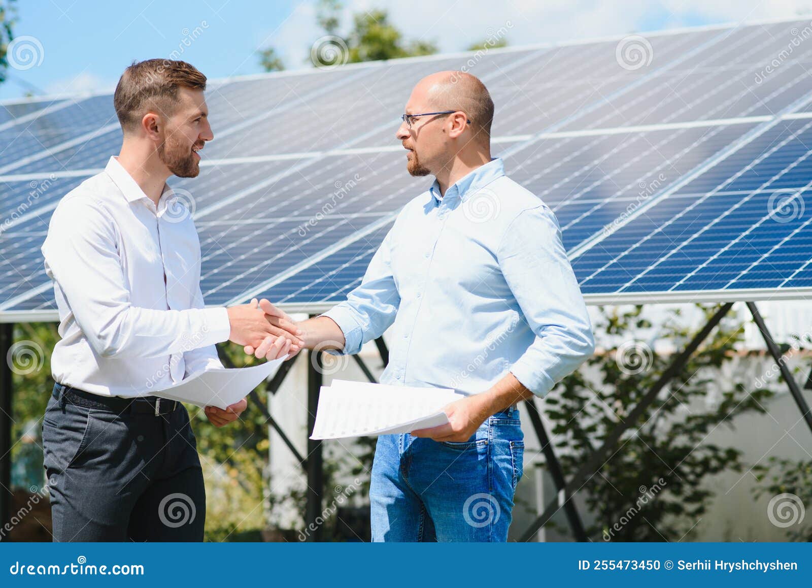 Two People Having a Shaking Hands Against Solar Panel after the ...