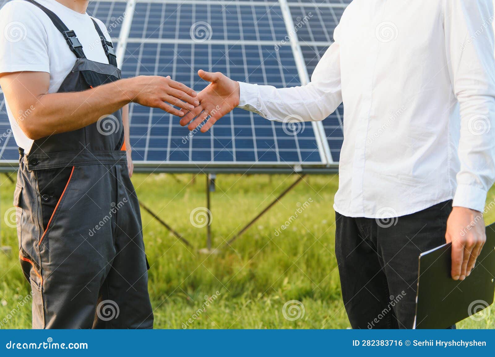 Two People Having a Shaking Hands Against Solar Panel after the ...