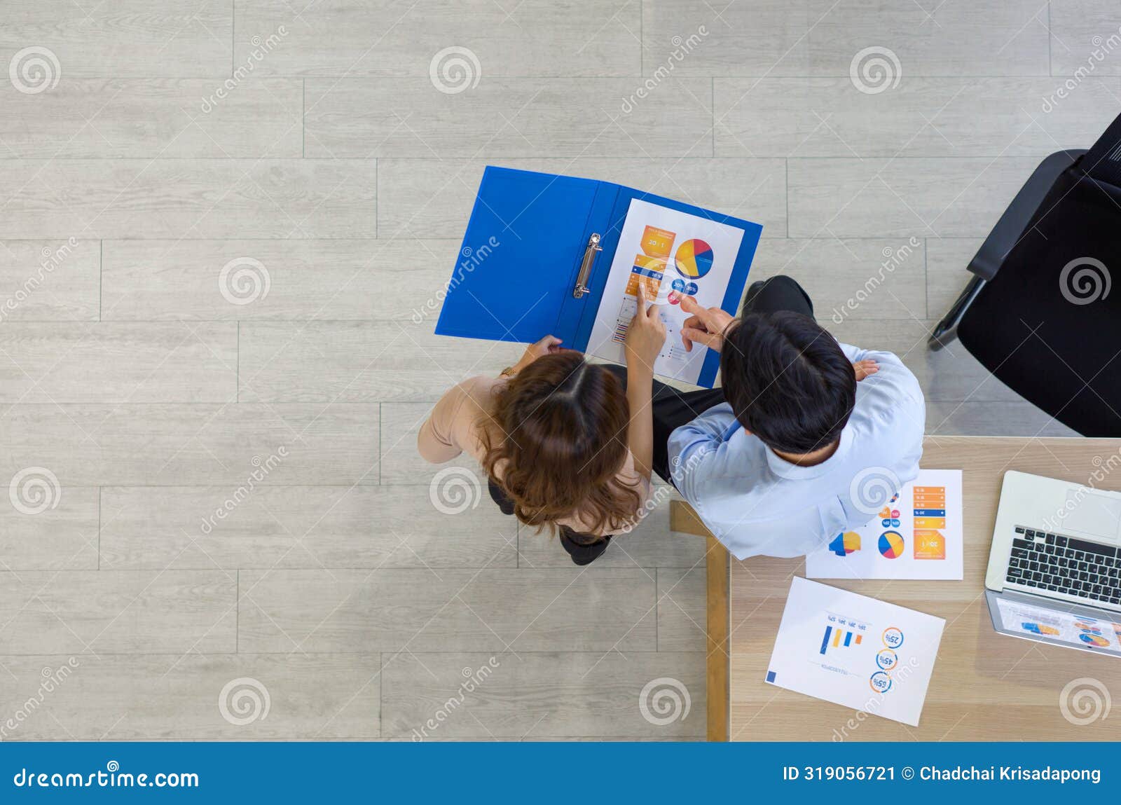 Two People are Looking at Chart and Graph during a Meeting from a Top ...