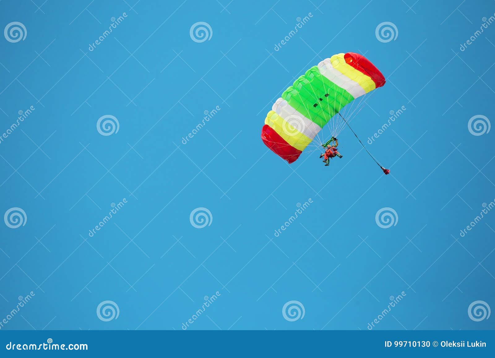 Two People on a Multi-colored Parachute in the Sky Stock Photo - Image ...