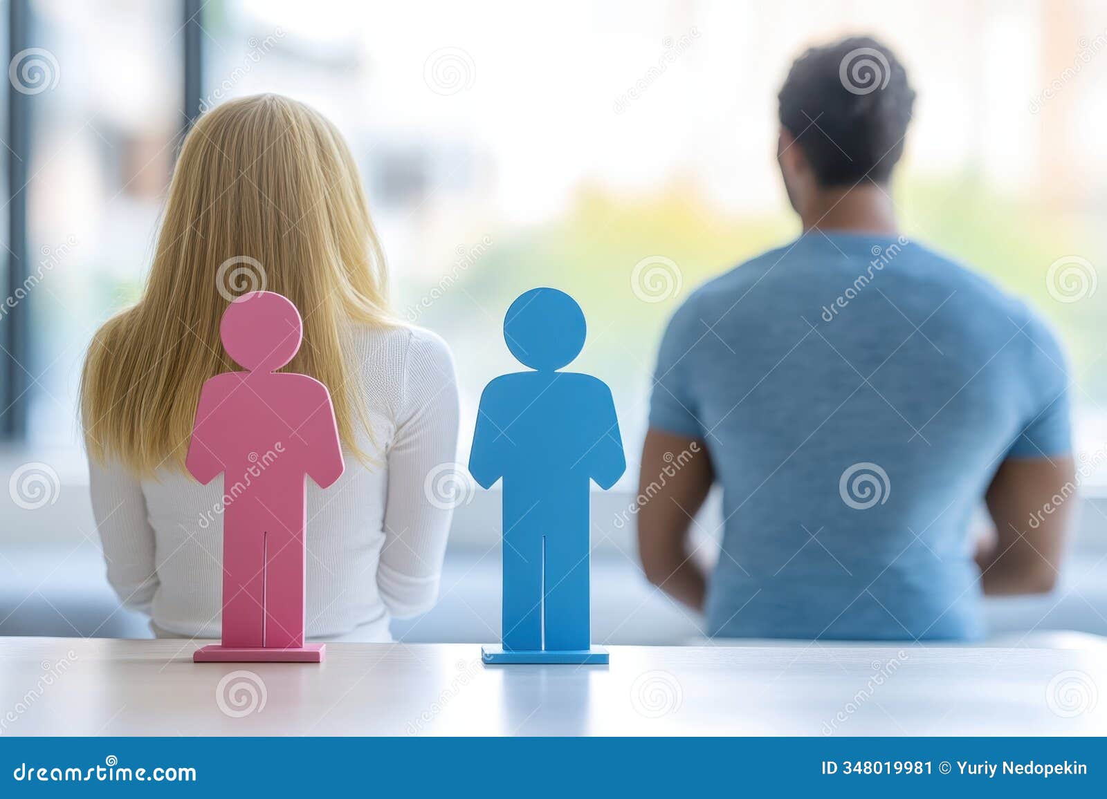 Two People Sitting Apart with Colored Figures Symbolizing Gender ...