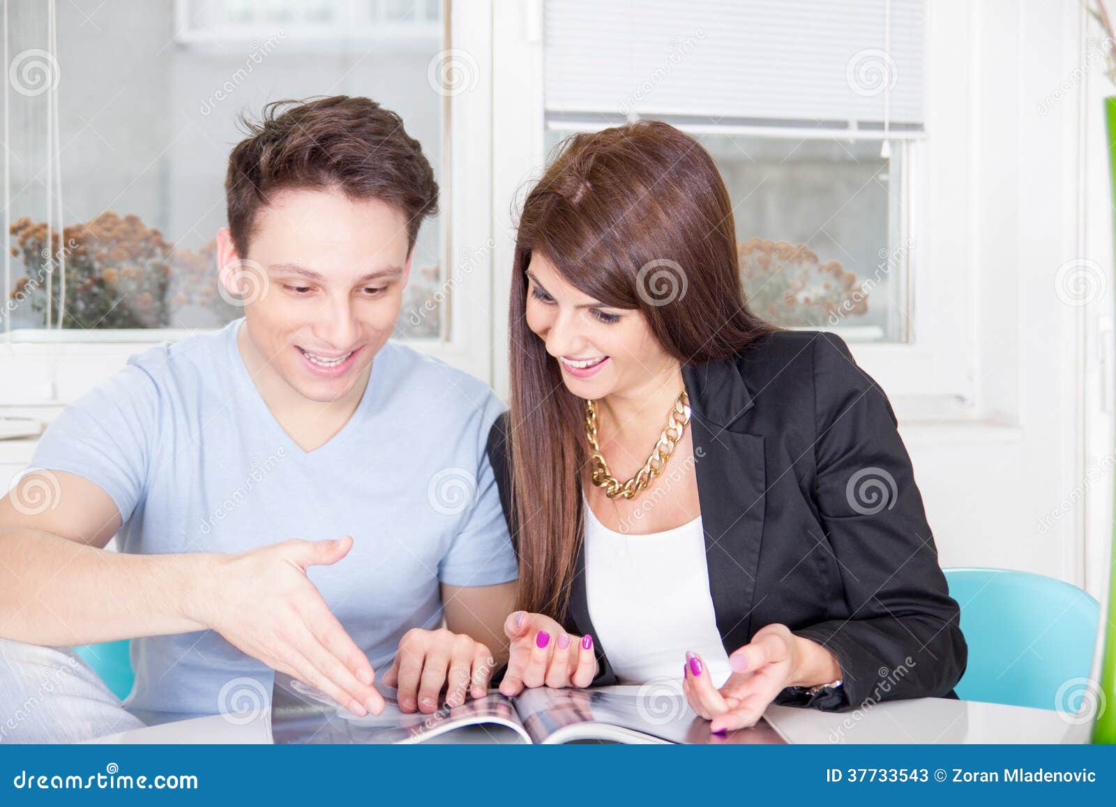 Two People Sitting at the Table Reading Magazine Stock Image - Image of ...