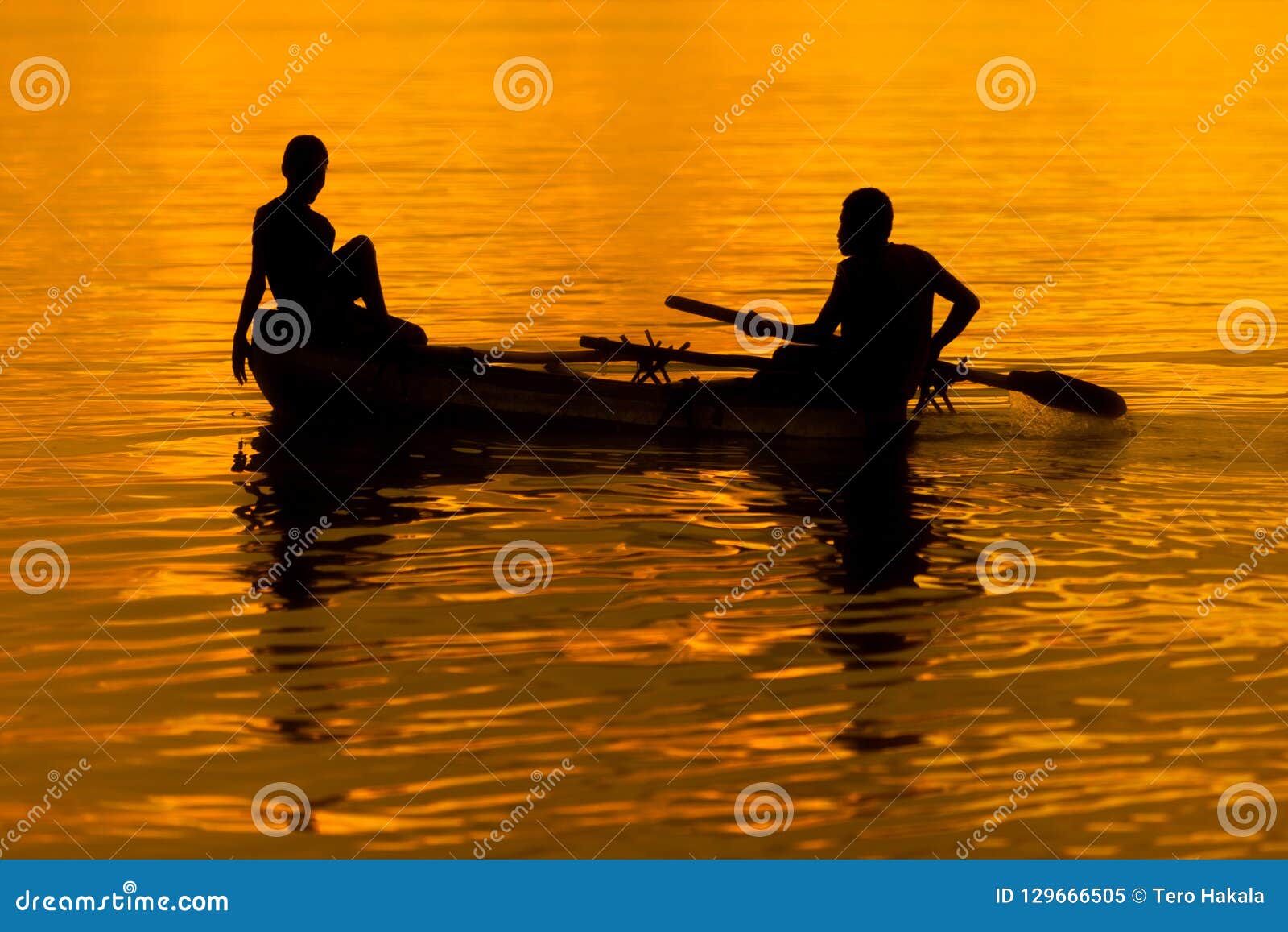 Two People in a Small Boat at Orange and Golden Sunset Stock Image ...
