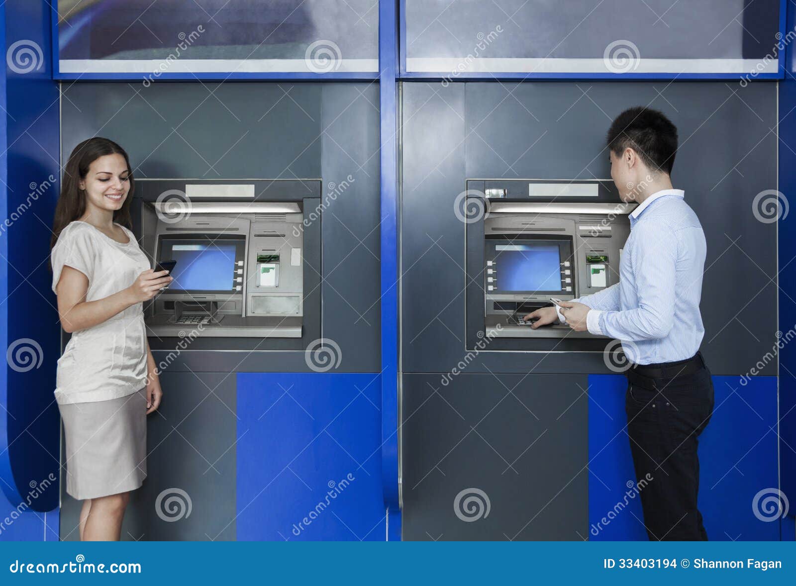 Two People Standing and Withdrawing Money from an ATM Stock Photo ...