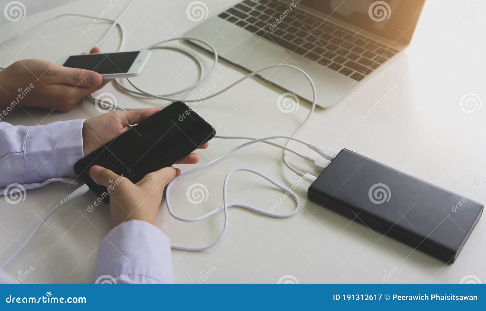 Two People Using Two Mobile Phone Sharing USB Power Bank on a Table To ...