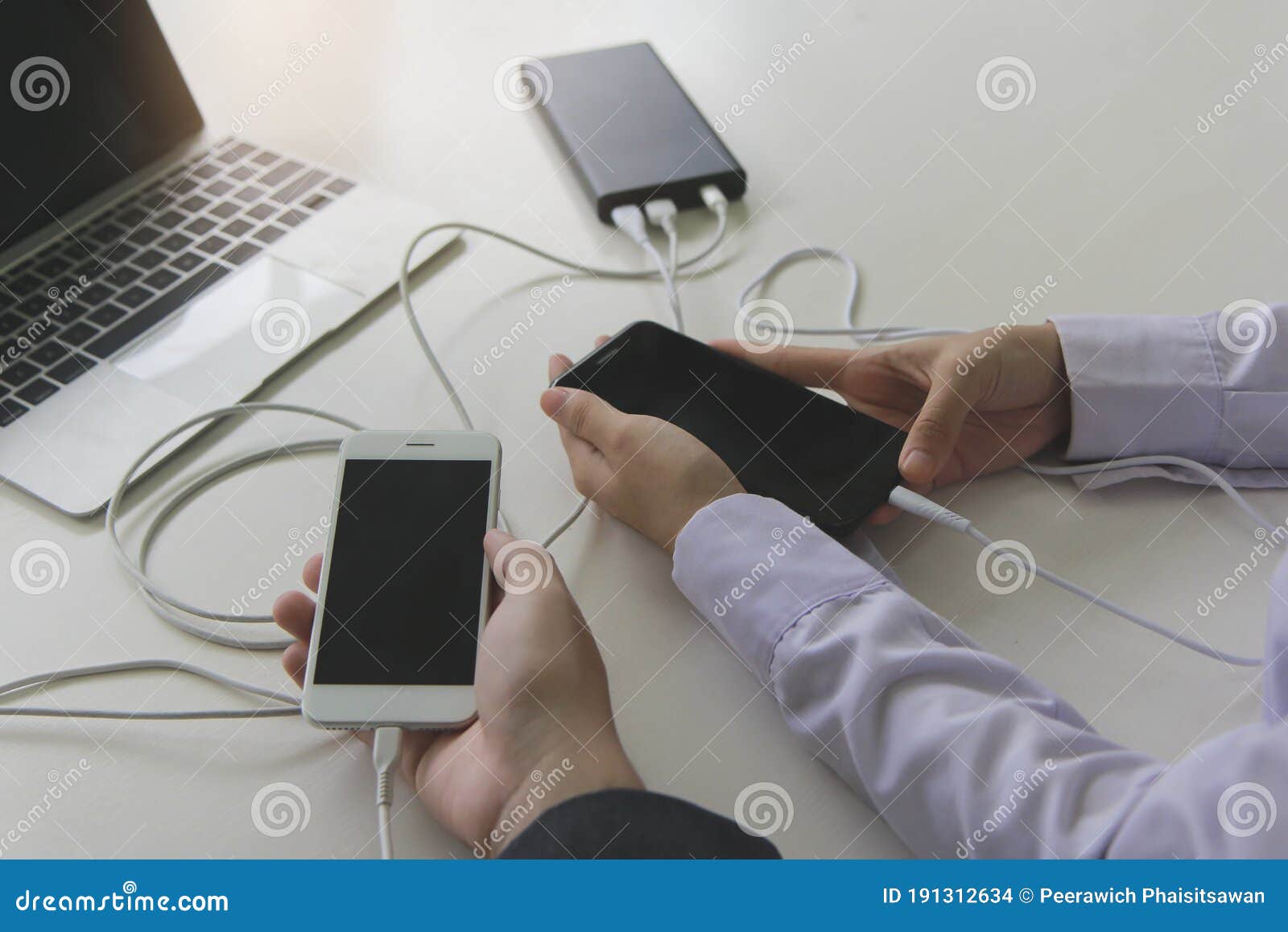 Two People Using Two Mobile Phone Sharing USB Power Bank on a Table To ...