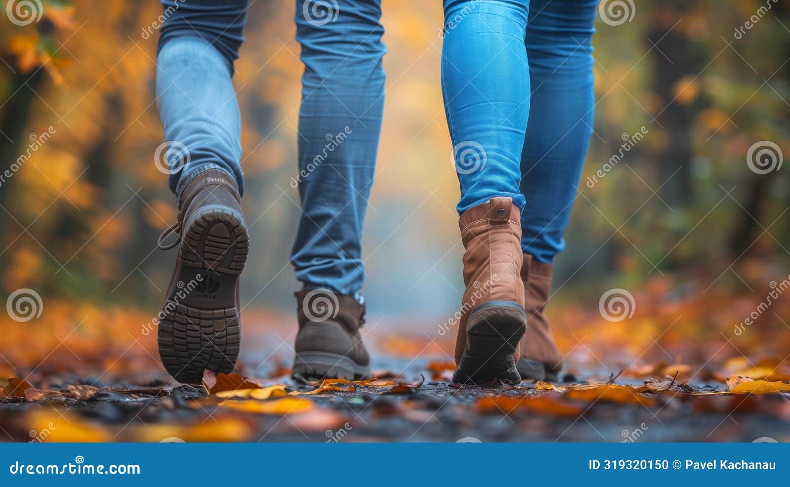 Two People Walking Side by Side Down a Road Covered in Fallen Leaves ...