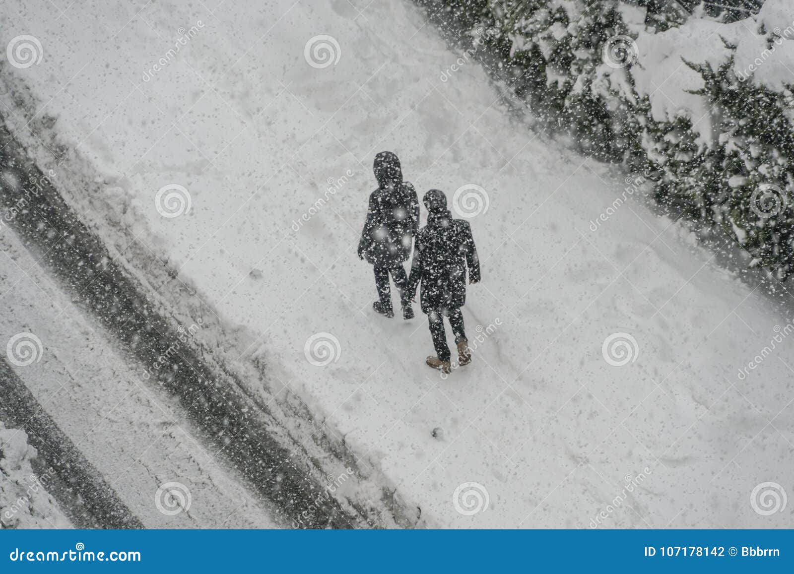 Two people walking on snow stock photo. Image of white - 107178142