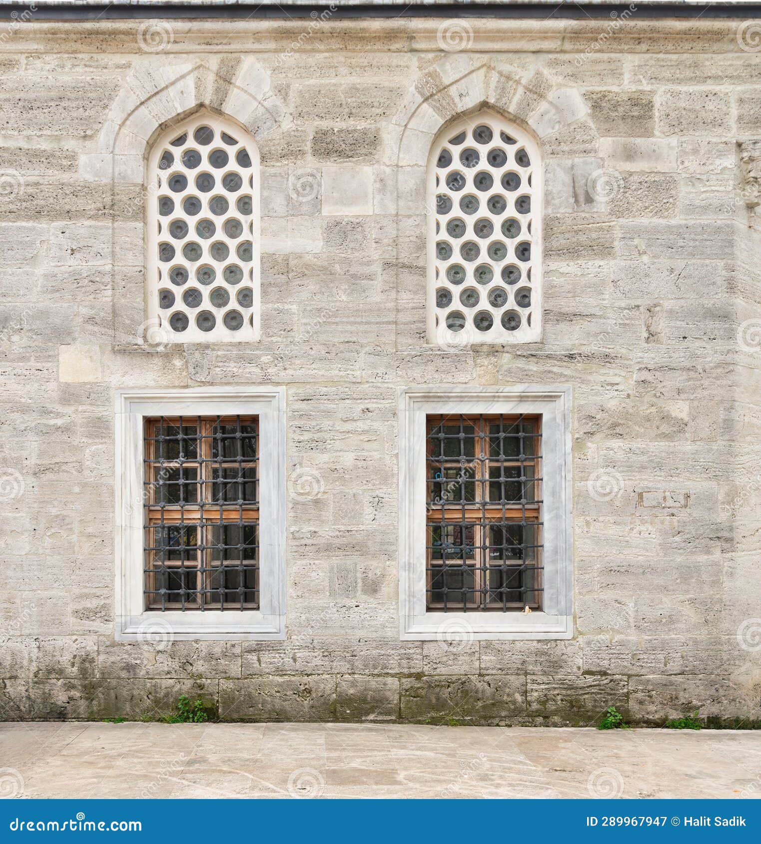 Two Perforated Arched Stucco Windows and Two Windows with Bars on a ...