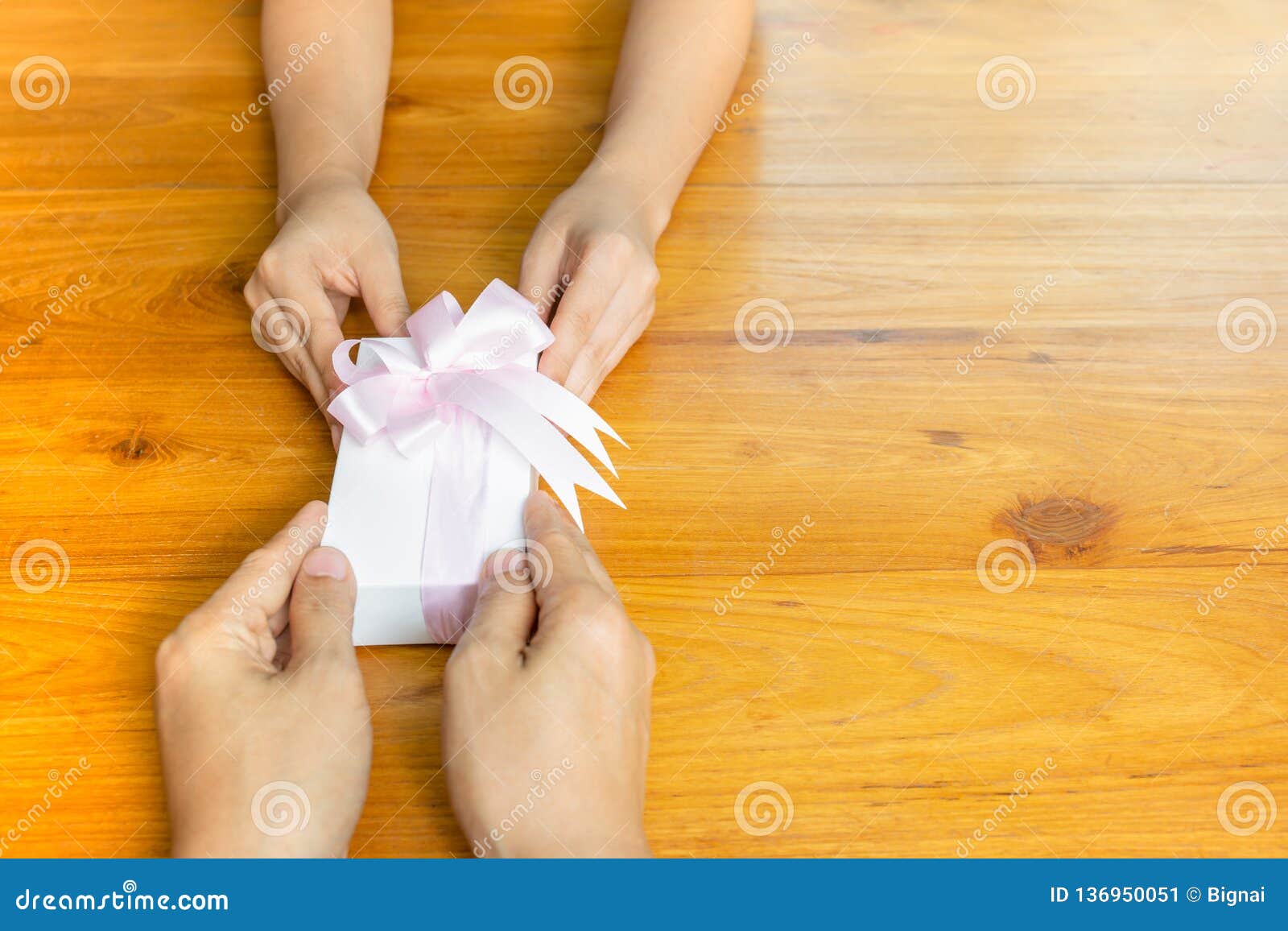 Two Persons Hands Giving and Receiving a Present Gift Box on Table ...