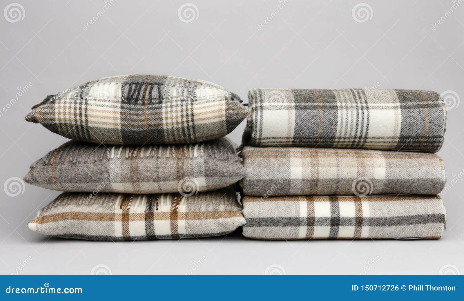 Two Piles of Natural Coloured Cushions and Throws, on a Grey Background ...
