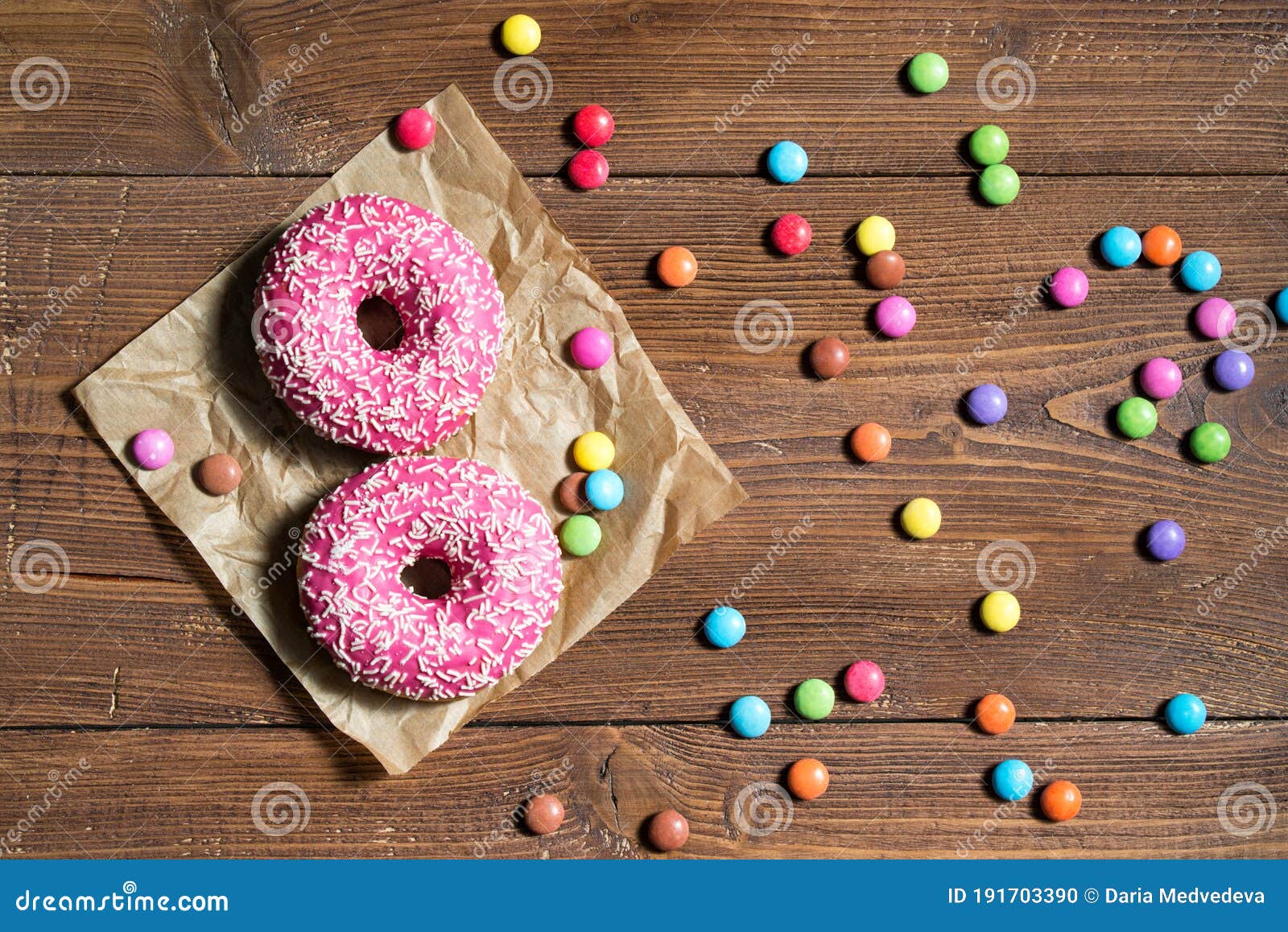 Two Pink Donuts and Colored Smarties on Wooden Table, Top View Stock ...