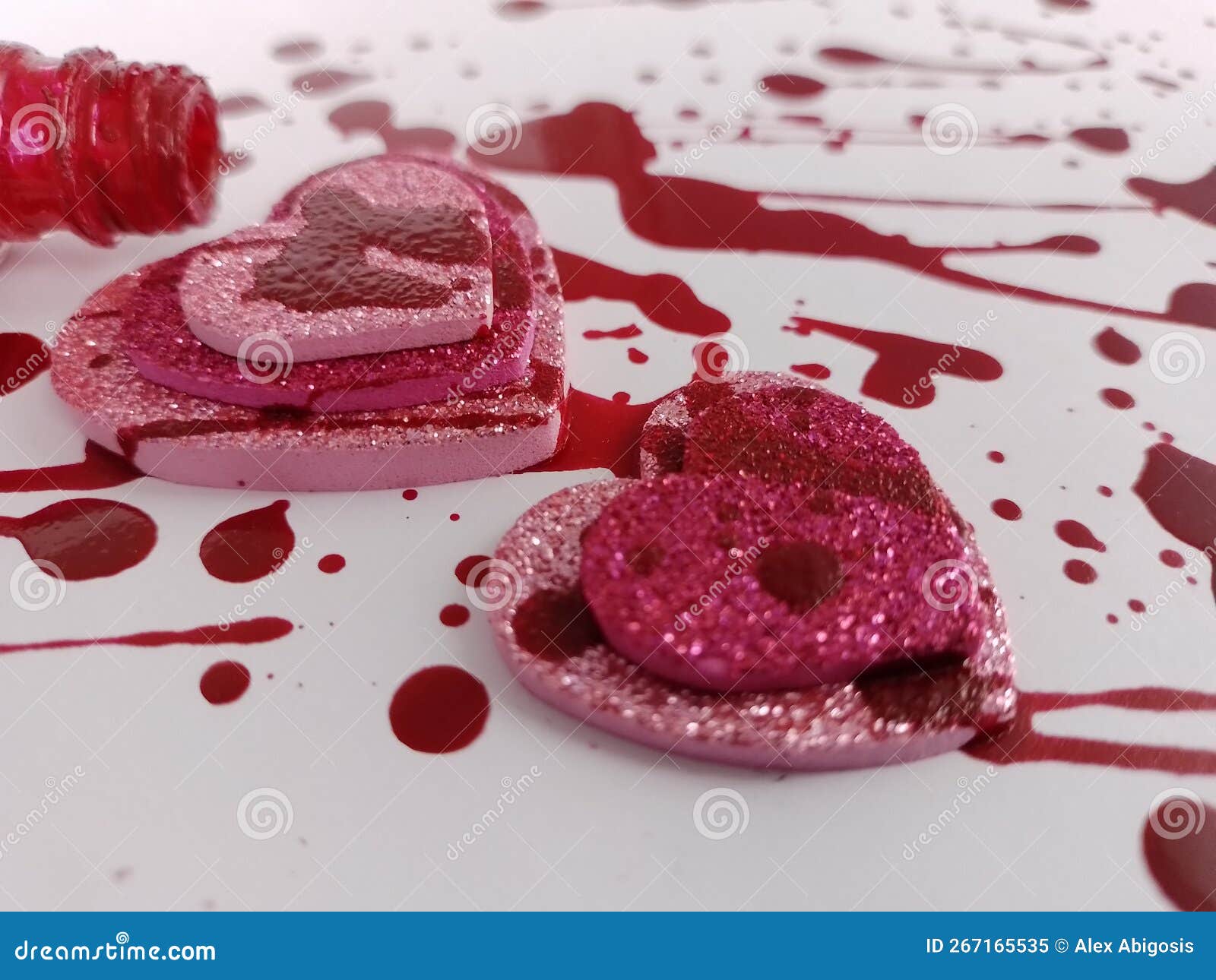 Two Pink Hearts with Red Paint Splatter and the Bottle on a White ...
