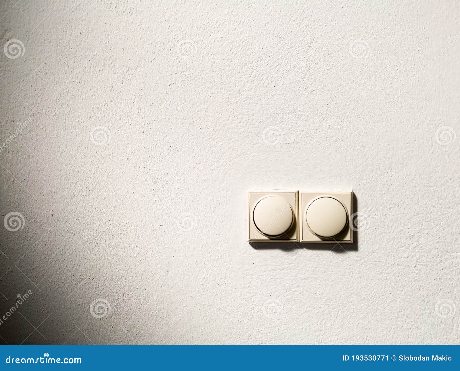 Two Plastic Light Switches on a White Painted Wall in the House in ...