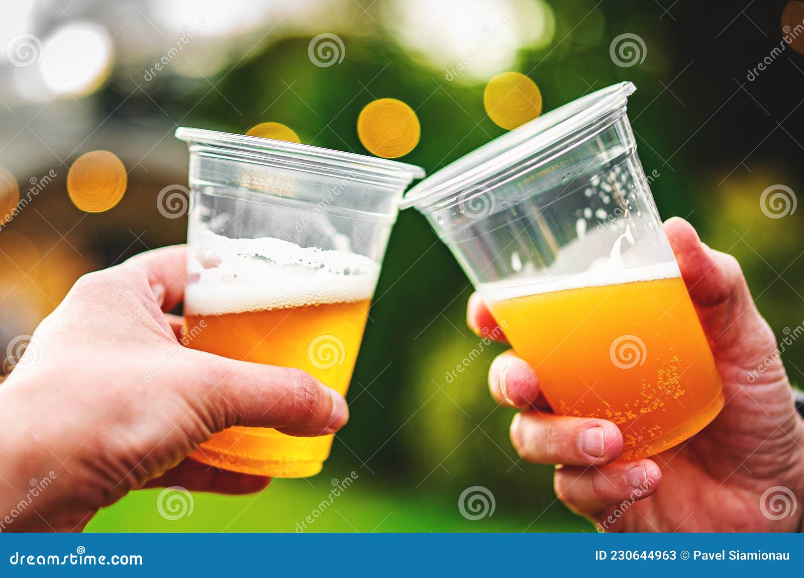Two Plastick Glass of Beer in Hand. Beer Clinking Stock Image - Image ...