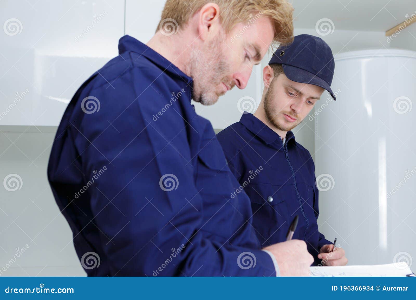 Two plumbers at work stock photo. Image of expert, service - 196366934