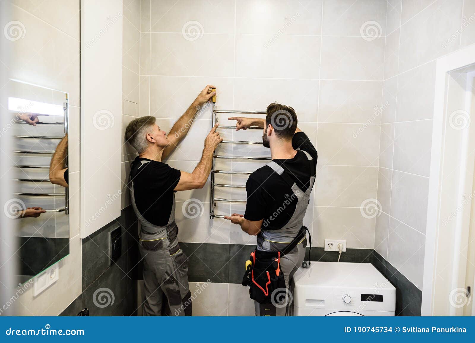 Two Plumbers, Workers in Uniform Working, Installing Towel Rail ...