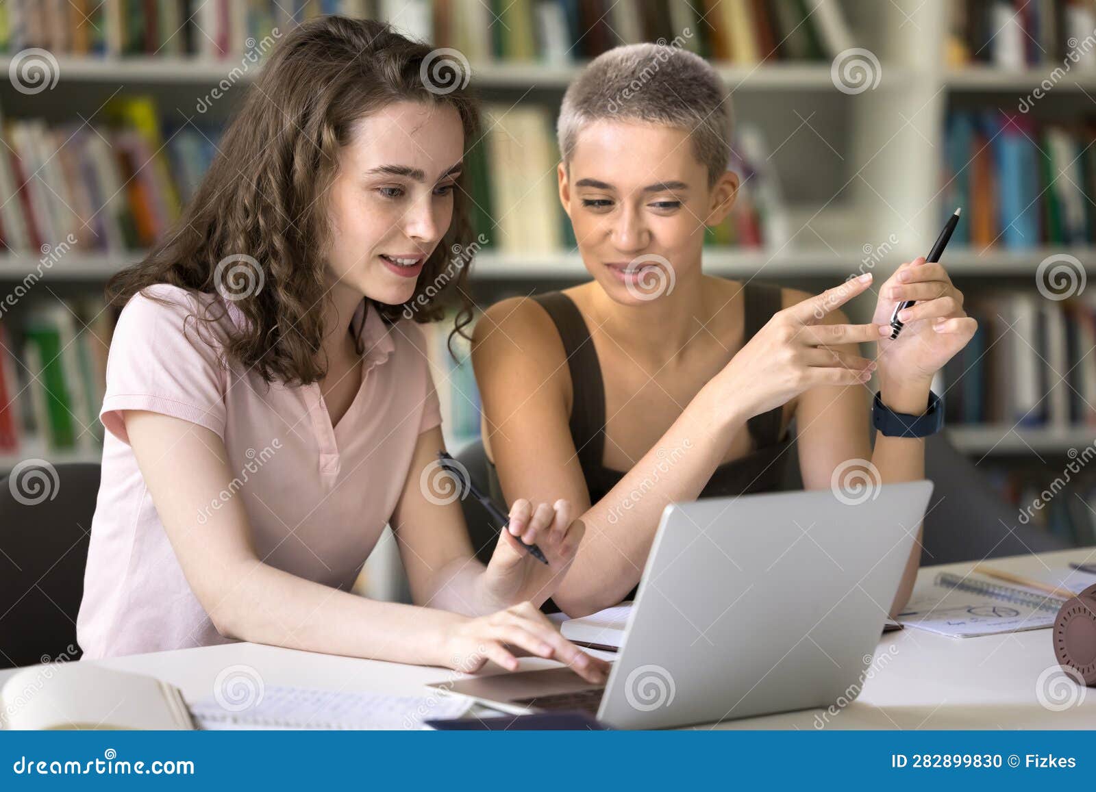 Two Positive Pretty Young Student Girls Studying in College Library ...