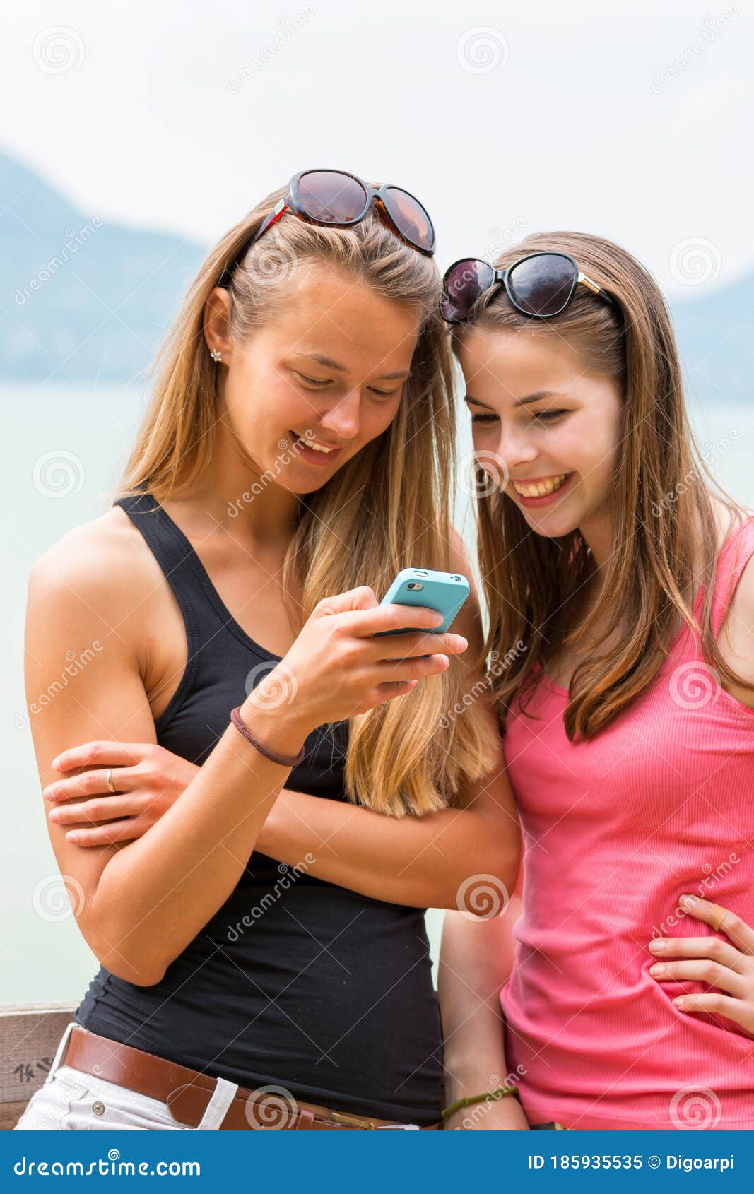 Two Pretty Young Girls Looking at Mobile Phone Stock Image - Image of ...