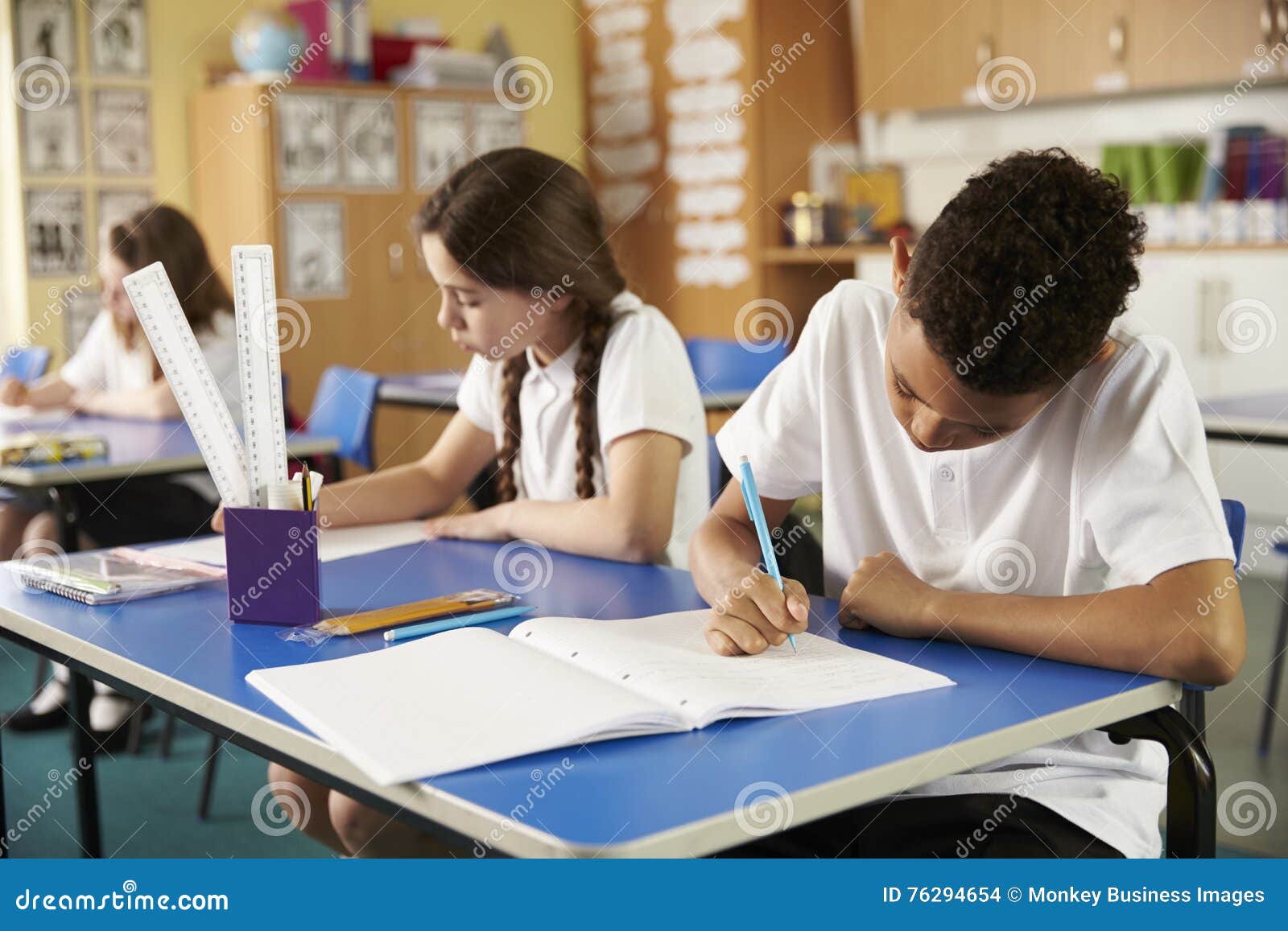 Two Primary School Pupils Working at Their Desks in Class Stock Photo ...