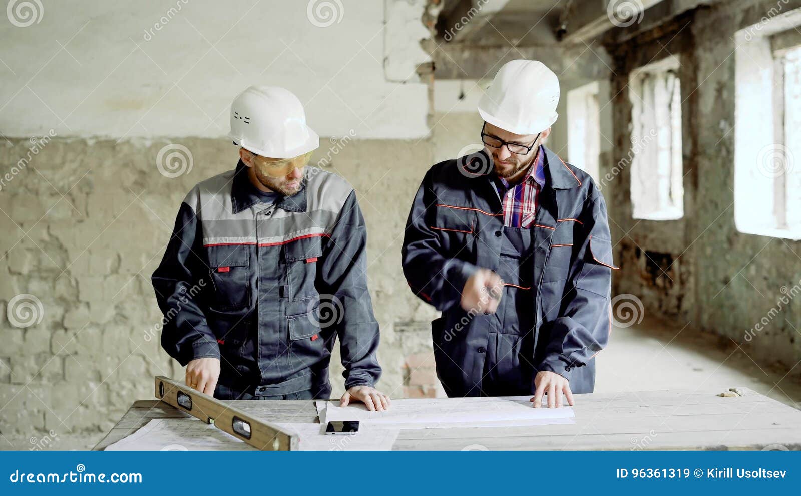Two Professional Engineers Working Together at the Desk with Building ...