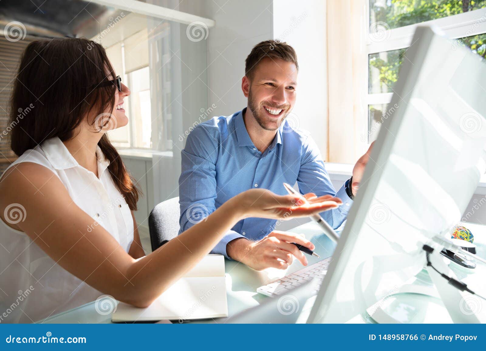 Two Businesspeople Looking at Computer Having Conversation Stock Photo ...
