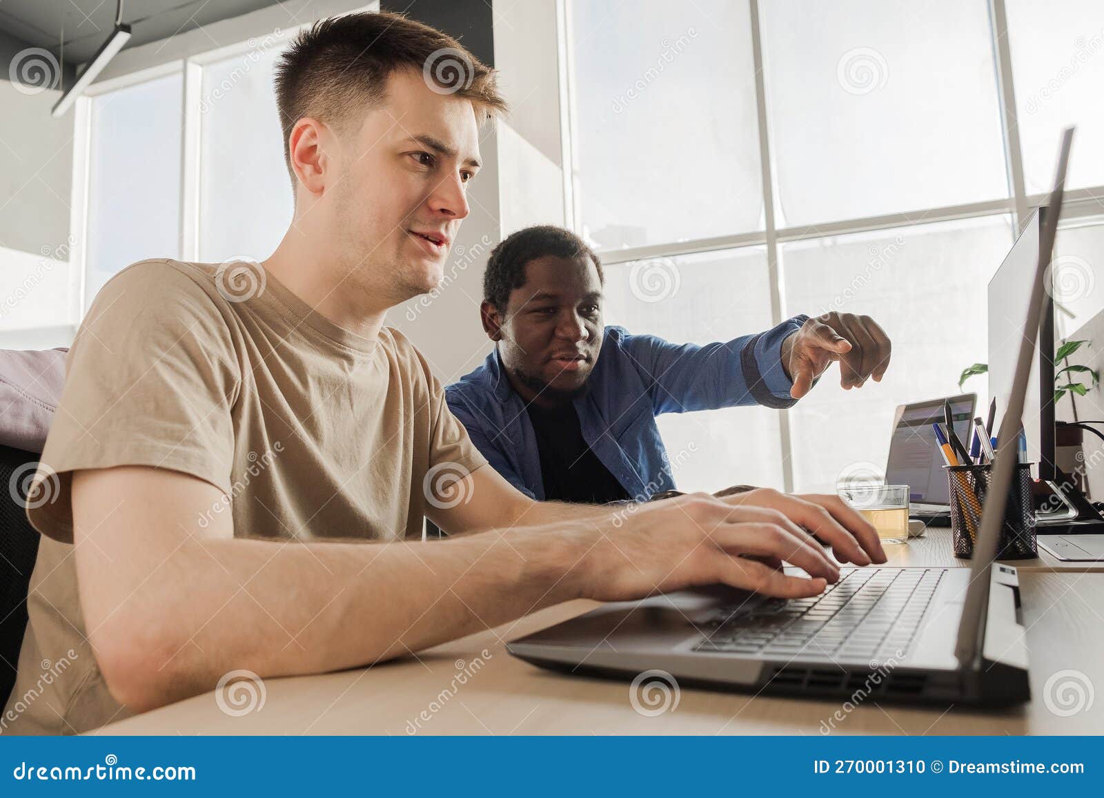 Two Programmers Working in the Office of a Software Development Company. Coding Technologies ...