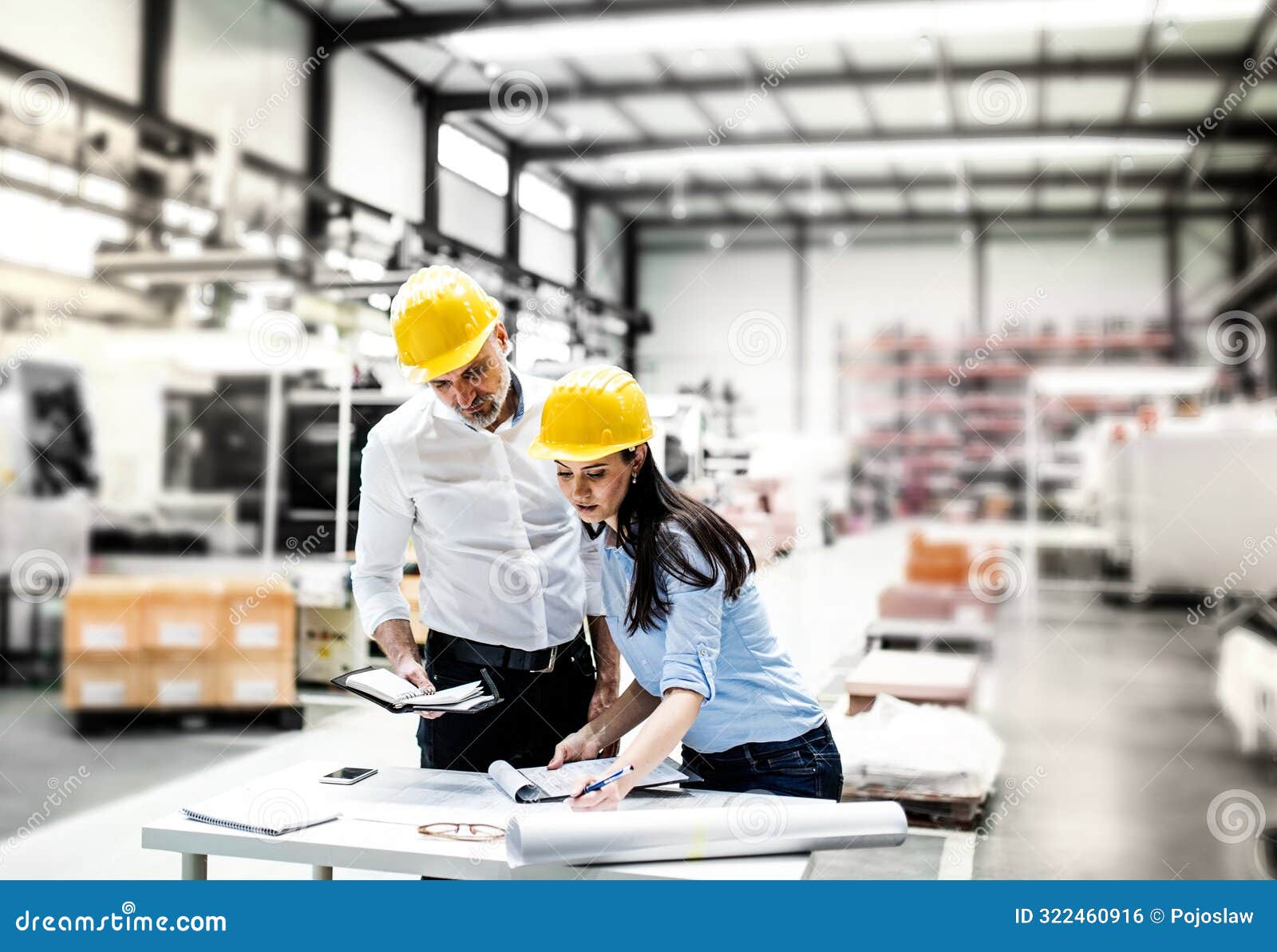 Two Project Managers Standing in Modern Industrial Factory, Looking ...