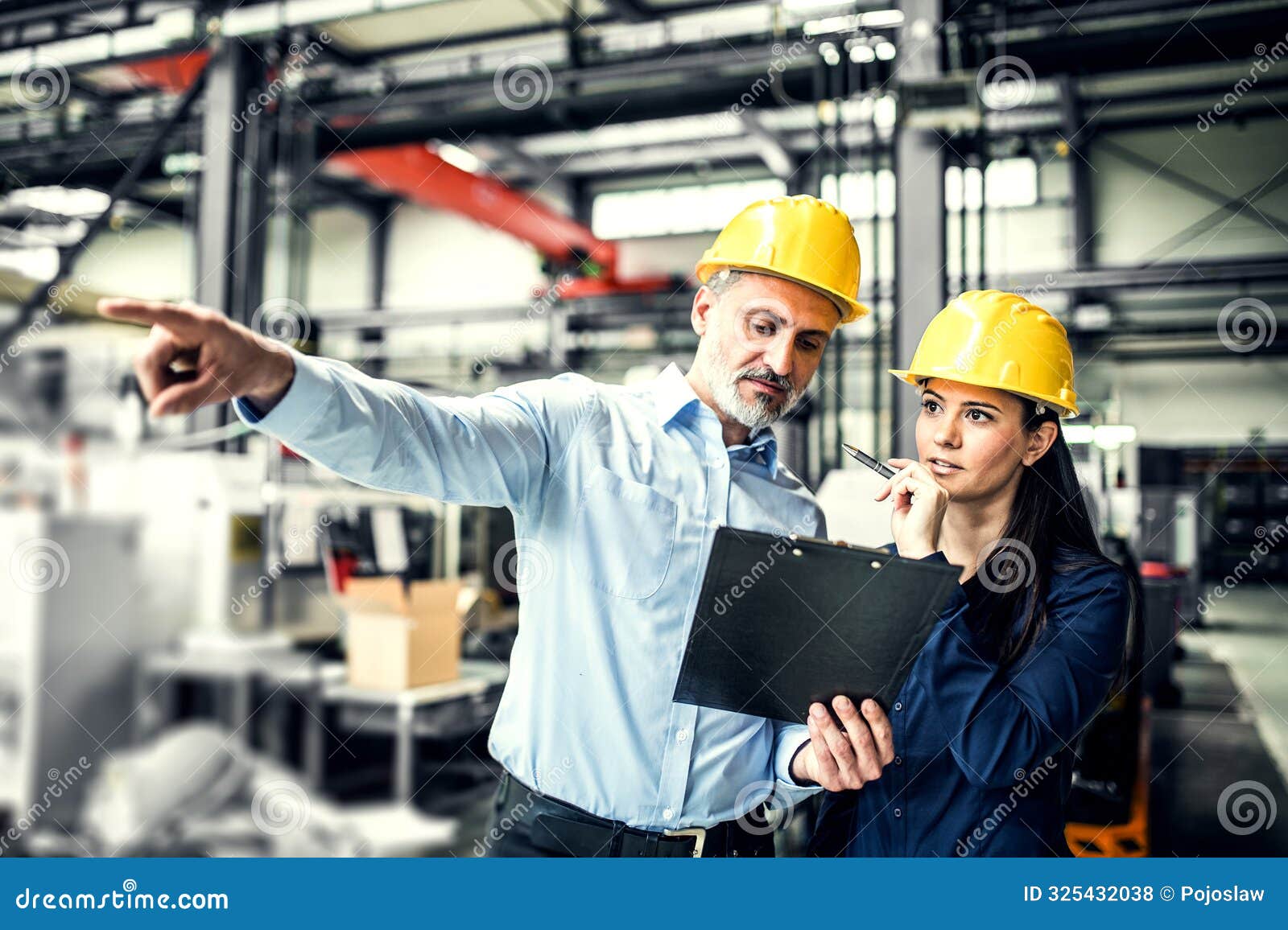 Two Project Managers Standing in Modern Industrial Factory, Looking ...