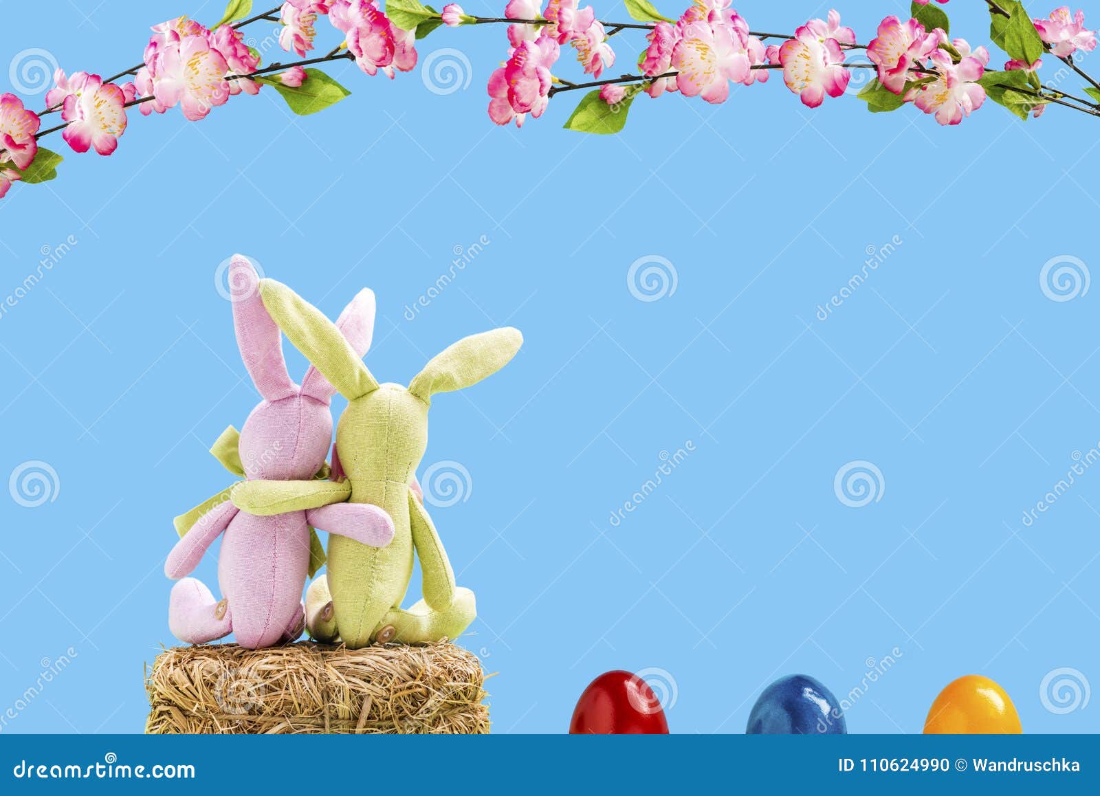 Two Rabbits on a Straw Bale with Easter Eggs and Flowers Stock Photo ...