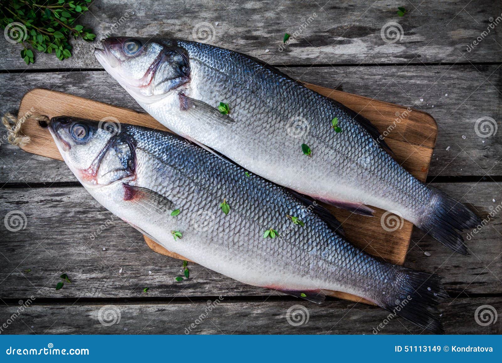 Two Raw Fresh Sea Bass on a Cutting Board with Thyme Stock Image ...