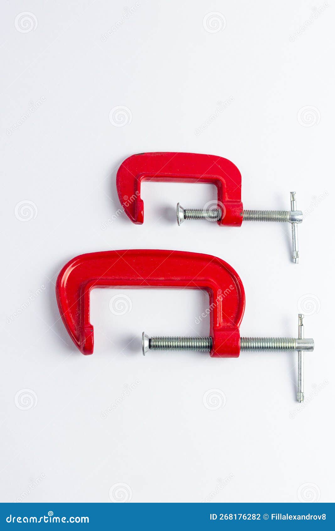 Two Red Metal Clamps of Different Sizes on a White Background Stock ...