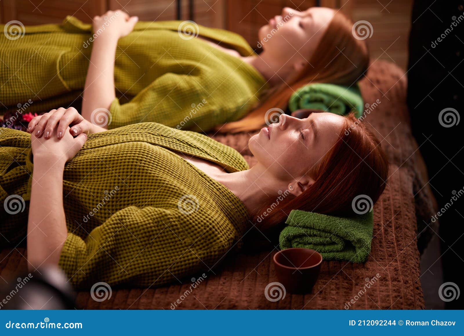 Two Redhead Ladies Lie On Bed Relaxing After Spa Treatment Massage